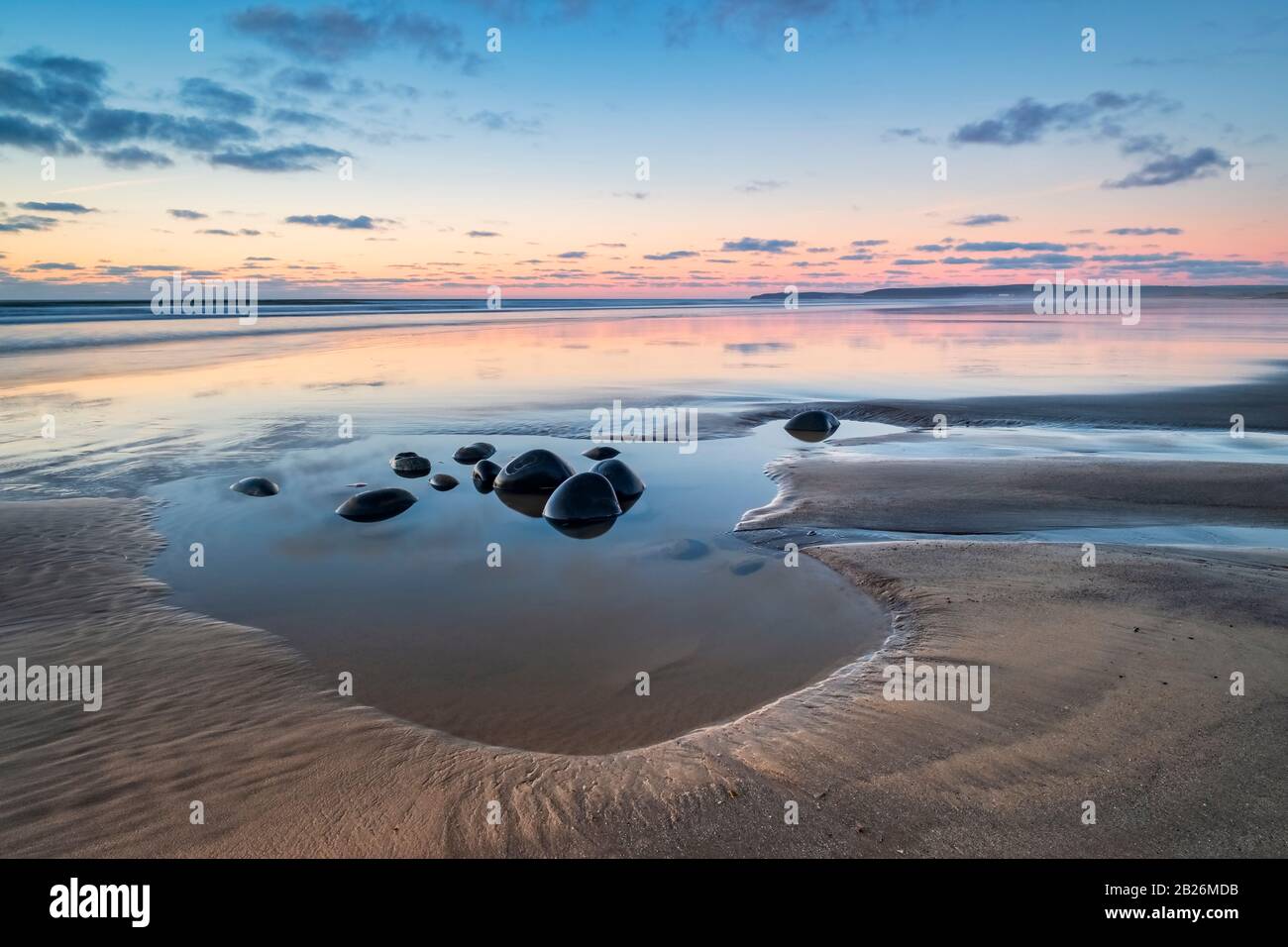 Pebbles in a rock pool on Westward Ho! Beach, North Devon with sunset ...