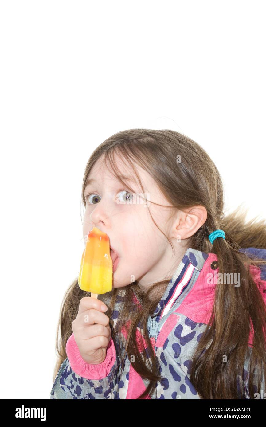 young girl eating an ice lolly with funny expression Stock Photo - Alamy