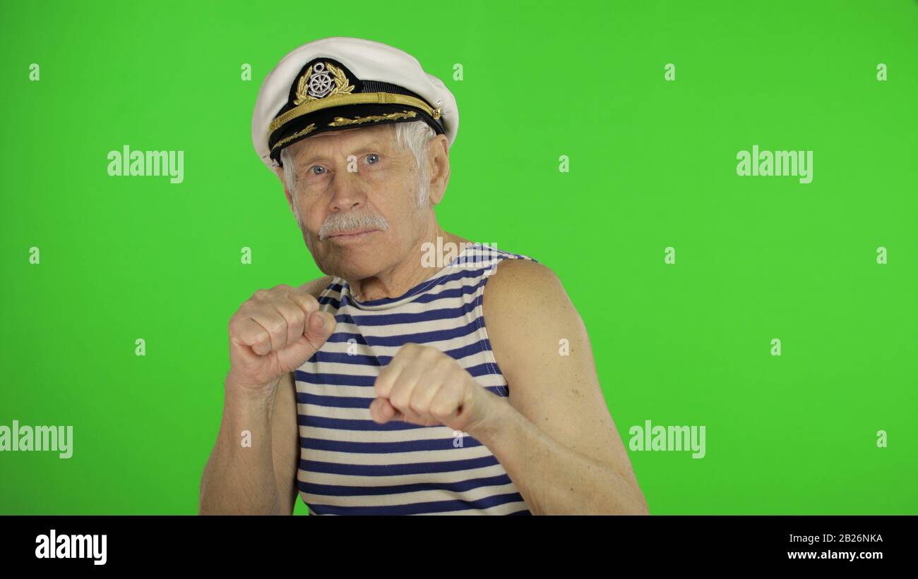 Elderly sailor man is angry and shows his fists. Old man with mustache ...