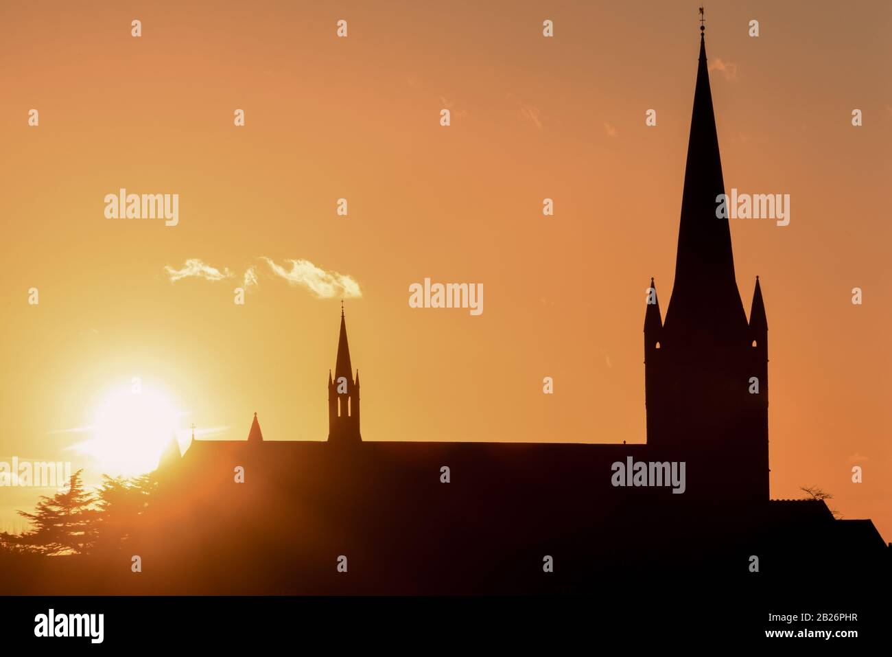 Church building exterior in silhouette of sunrise or sunset with ...