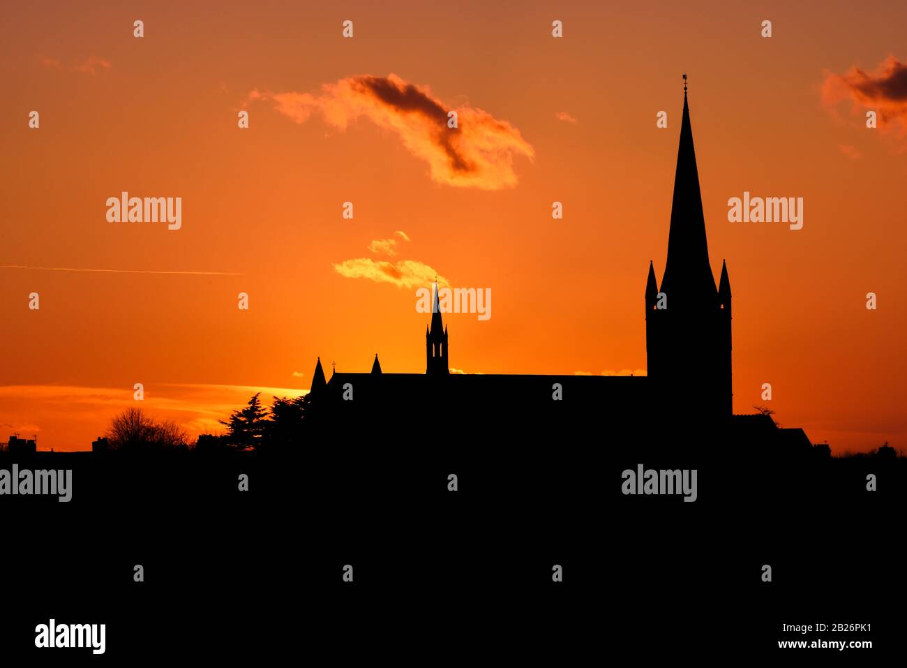 Church building exterior in silhouette of sunrise or sunset with ...