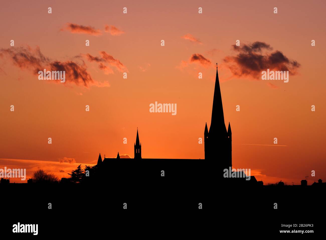 Church building exterior in silhouette of sunrise or sunset with ...