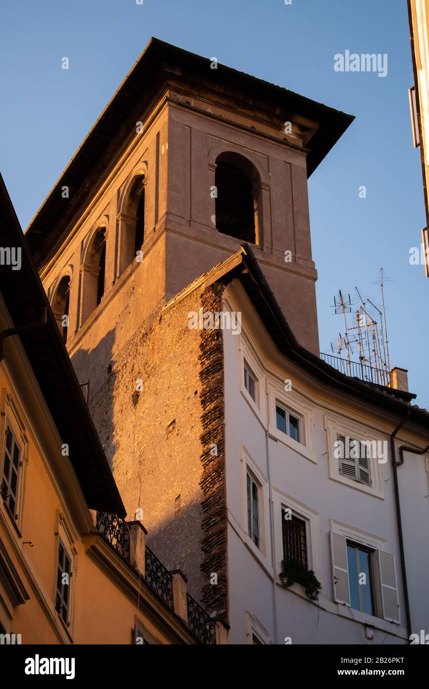 An architectural shot of a roman church tower overlooking a narrow ...