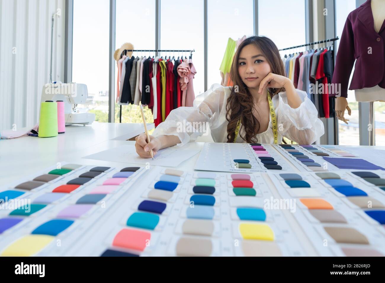 Wide angle view a young adult fashion designer drawing and sketching ...