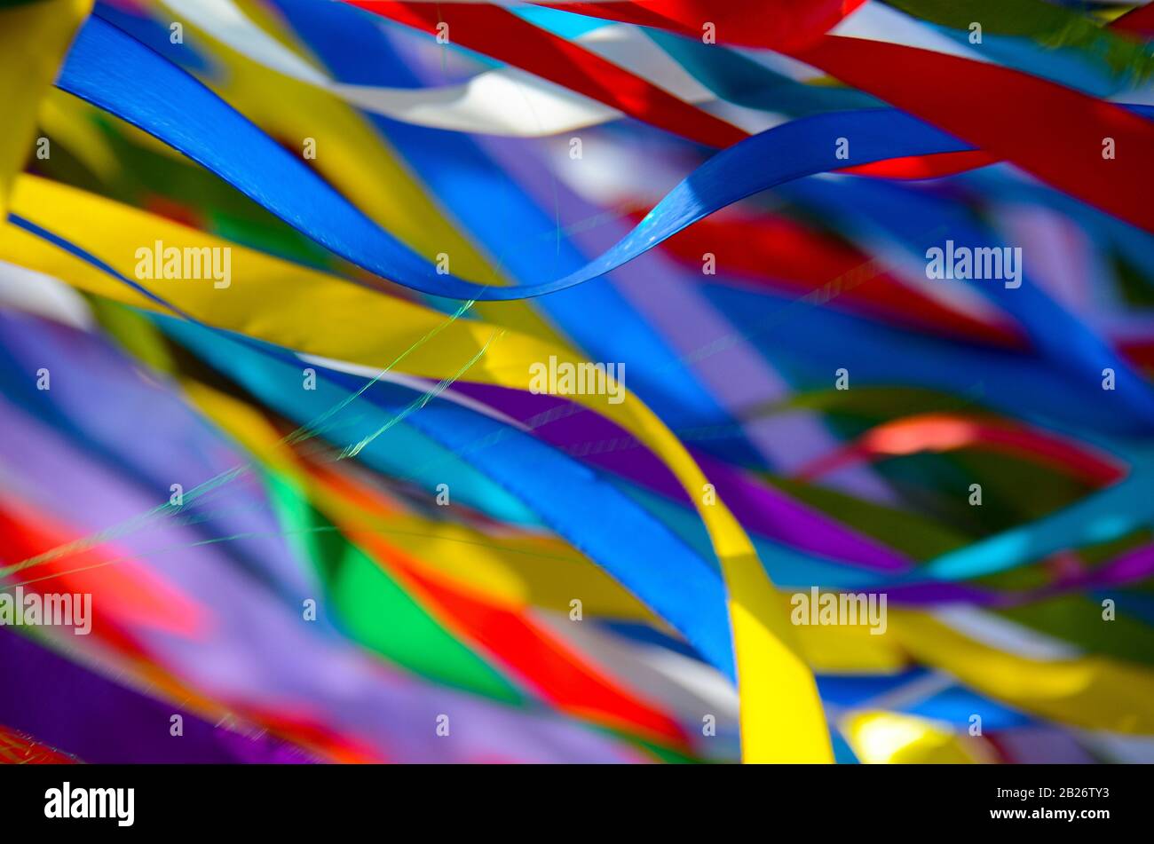 Many multicolored ribbons flutter in the wind in the sun. background ...