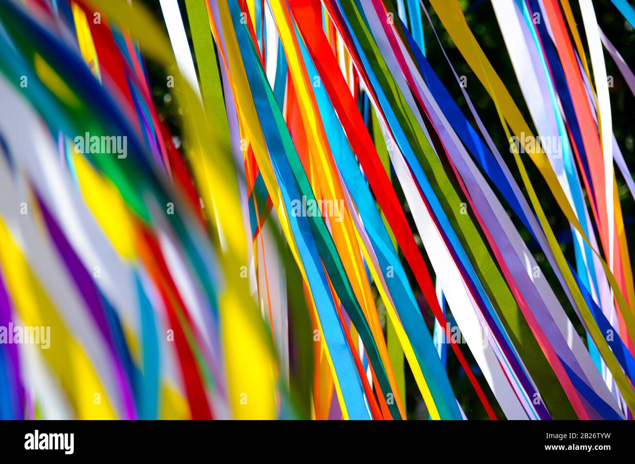 Many multicolored ribbons flutter in the wind in the sun. background ...