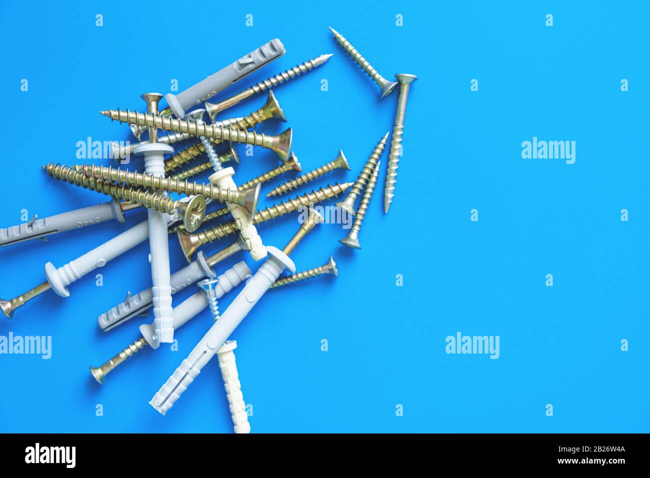 Many different nails screws nuts bolts on blue background of the copy ...