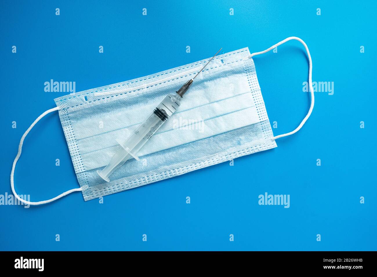 Medical protective mask syringe on a blue background. A typical 3-layer ...