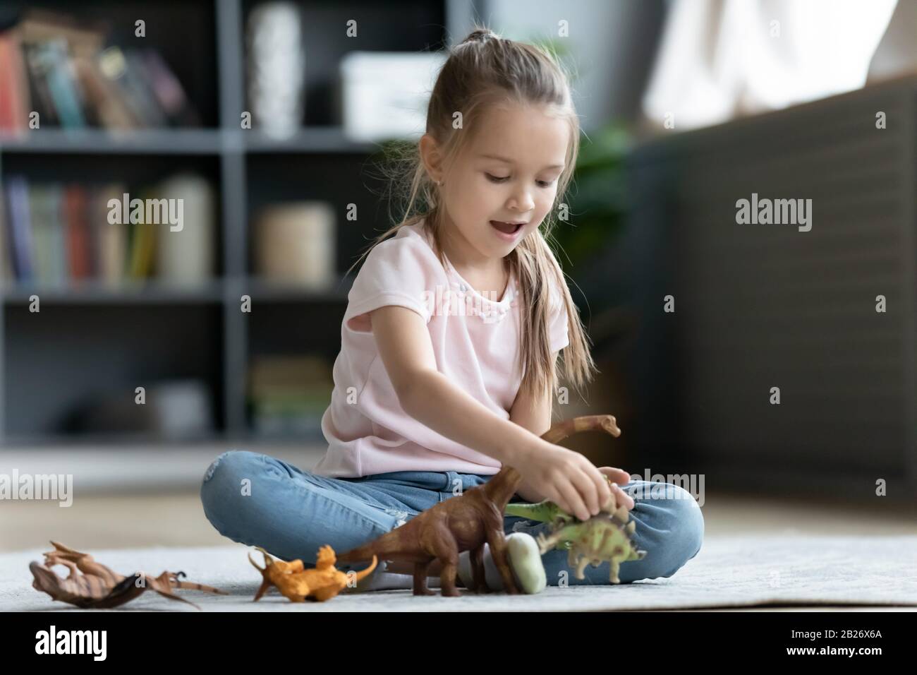 Little girl sit on floor playing with plastic figures Stock Photo - Alamy
