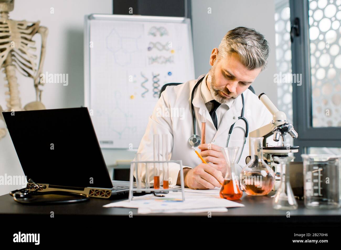 senior male researcher carrying out scientific research in a lab using ...