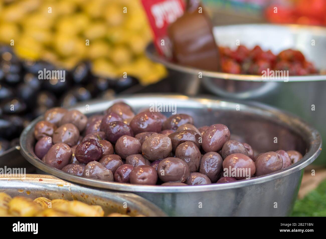 A pile of shiny Syrian brown olives and full of oil. Inside a metal ...