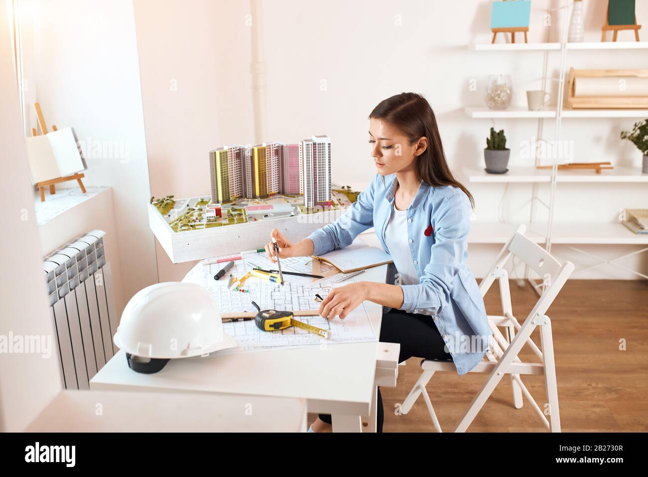 beautiful talented architect or engineer working on blueprint planning ...