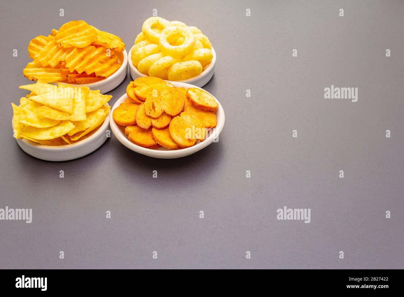 Assorted salty spiced snacks. Chips, rings, nachos, crackers. In ...