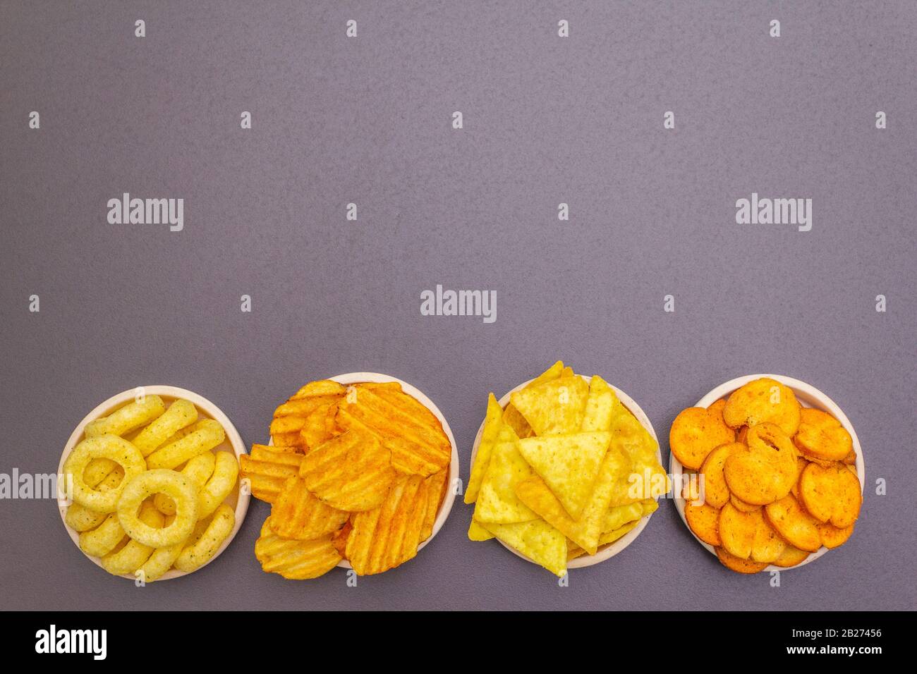 Assorted salty spiced snacks. Chips, rings, nachos, crackers. In ...