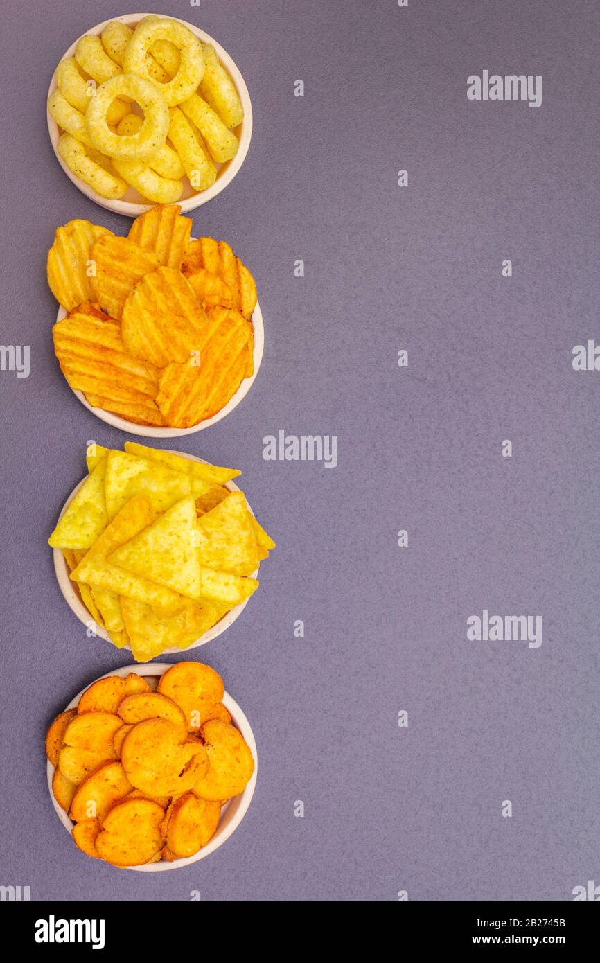 Assorted salty spiced snacks. Chips, rings, nachos, crackers. In ...
