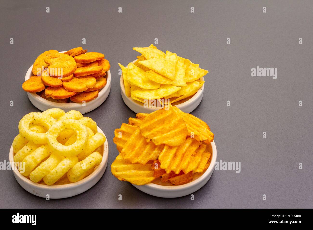 Assorted salty spiced snacks. Chips, rings, nachos, crackers. In ...