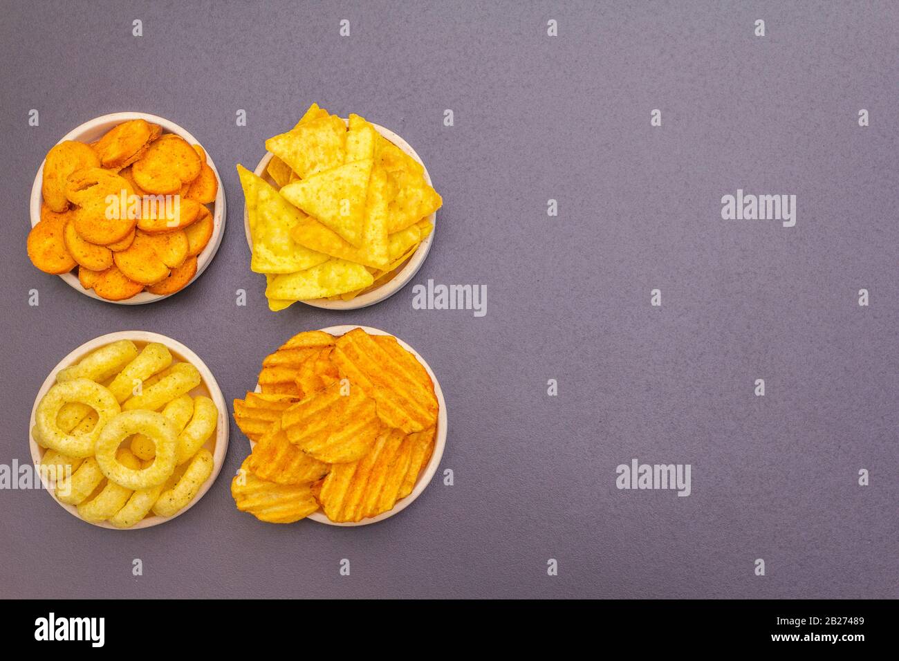 Assorted salty spiced snacks. Chips, rings, nachos, crackers. In ...