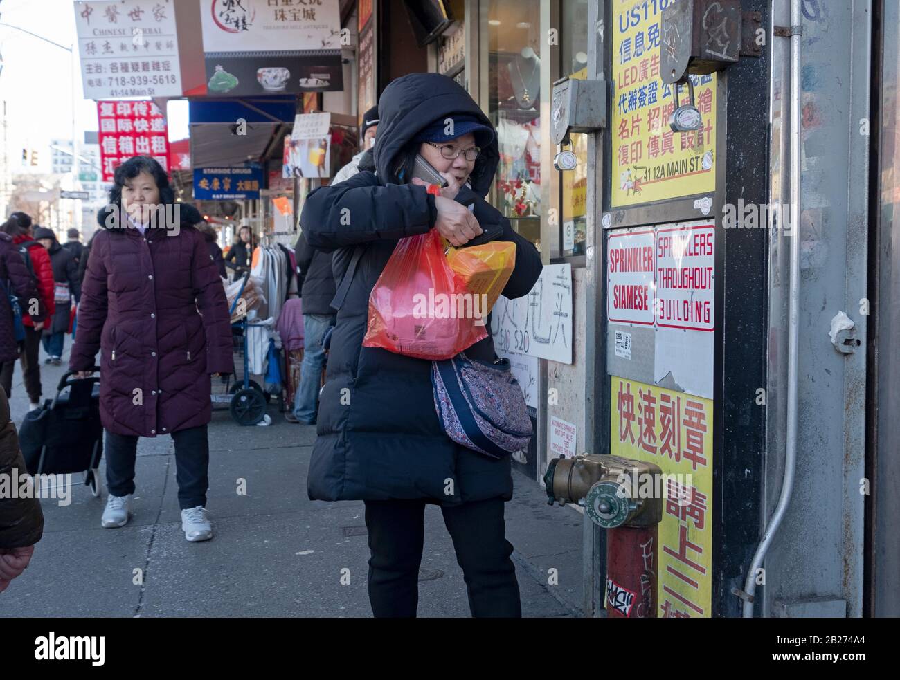 A middle aged Chinese American woman walks on Main Street carrying ...