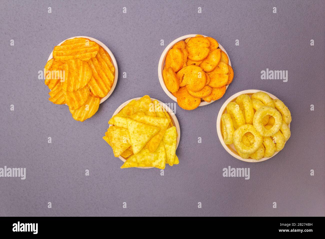Assorted salty spiced snacks. Chips, rings, nachos, crackers. In ...