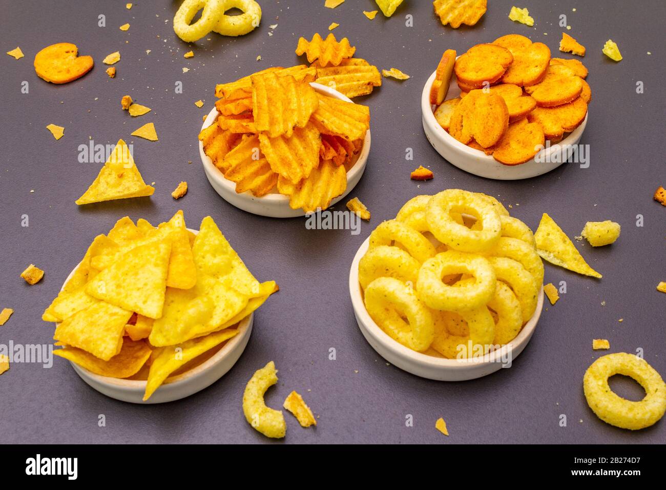 Assorted salty spiced snacks. Chips, rings, nachos, crackers. In ...