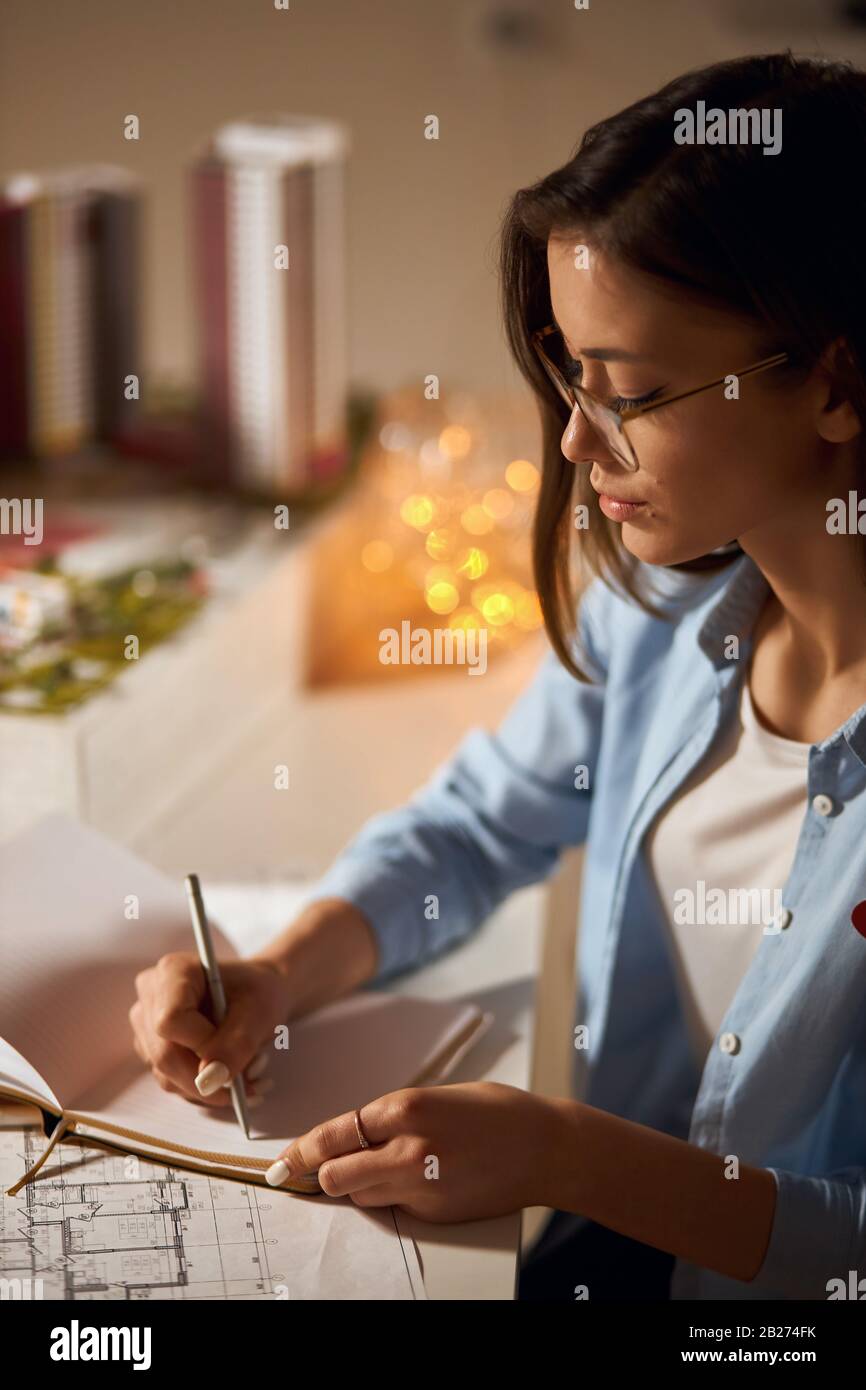 attractive girl writing something in her diary, concentration, plan of ...