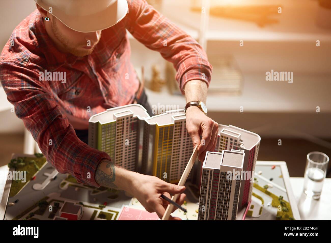 Architect in protective white helmet working with a ruler, examining ...