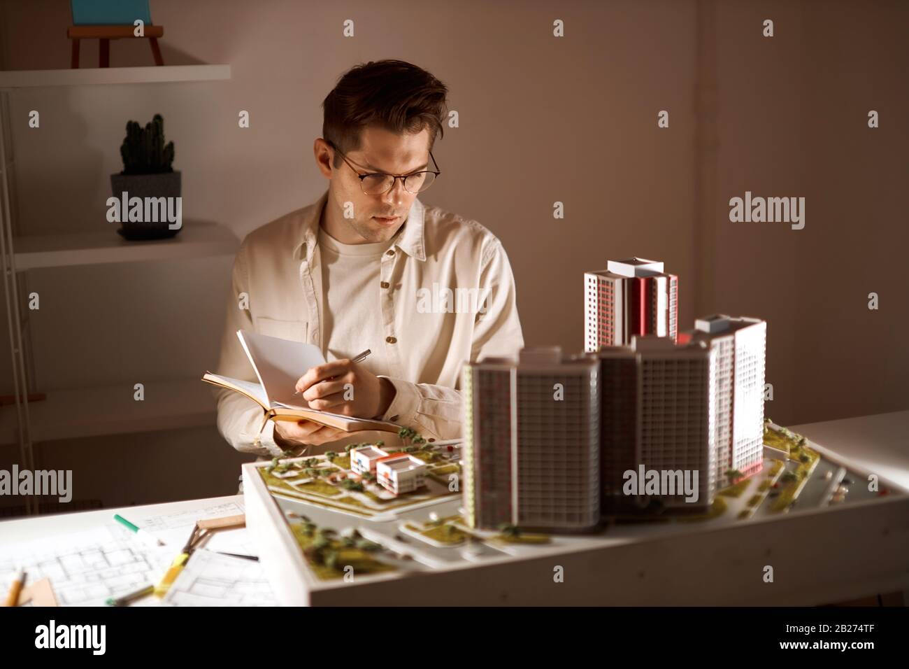 young serious designer finding some mistakes in the model, close up ...