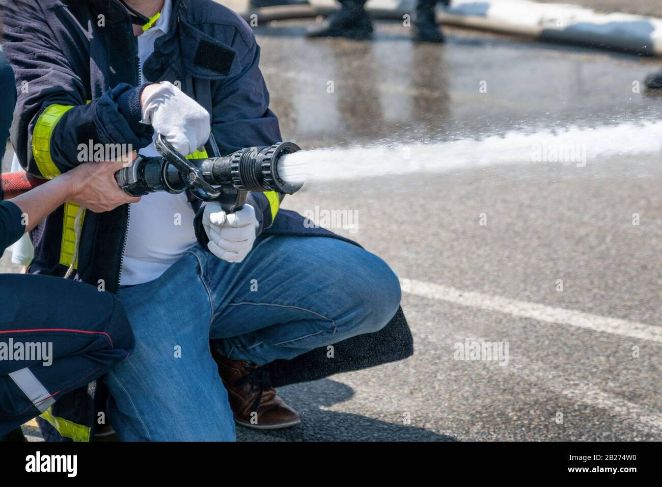 Firefighter shows trainee how to extinguish a fire with water Stock ...