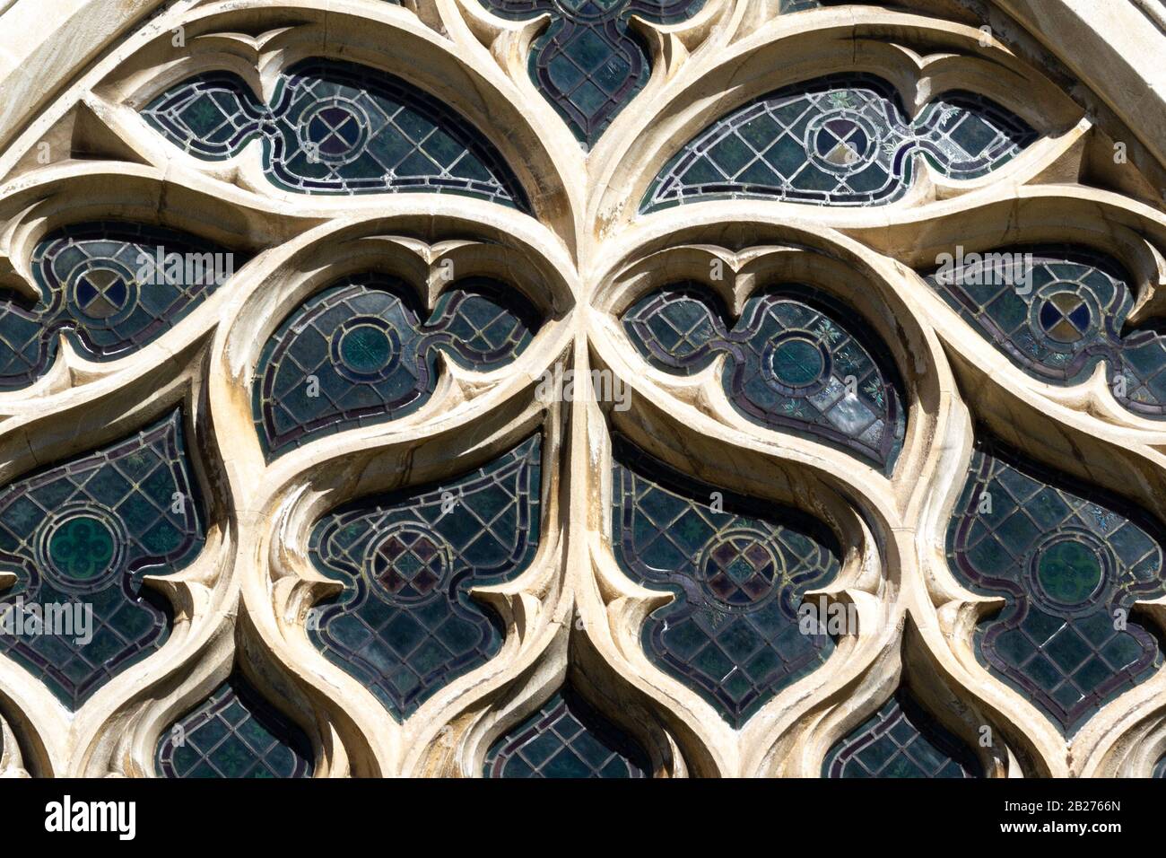 Detail of a stained glass window in a sandstone frame in a historic ...
