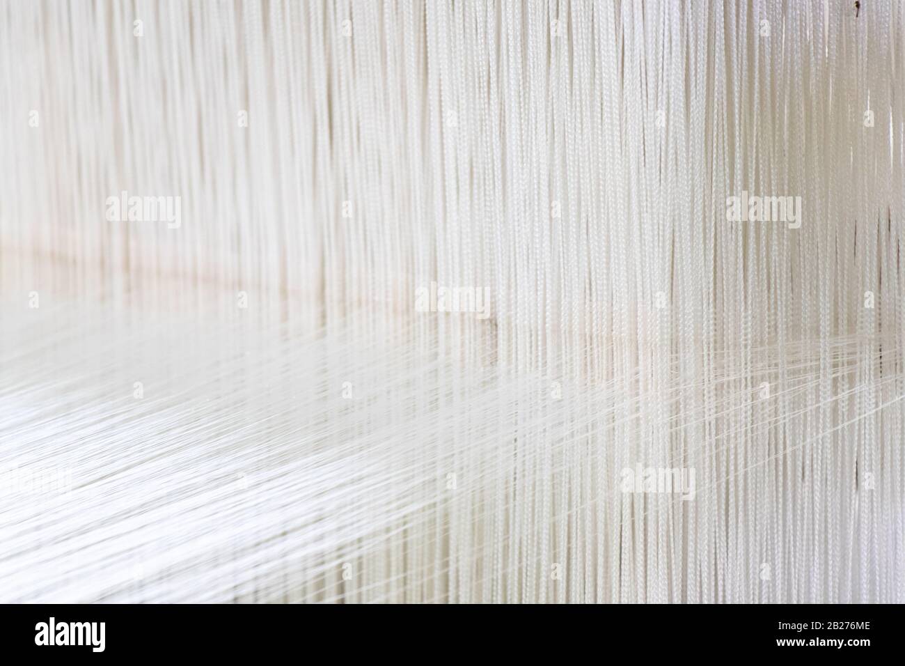 Closed up of loom with white thread background Stock Photo - Alamy