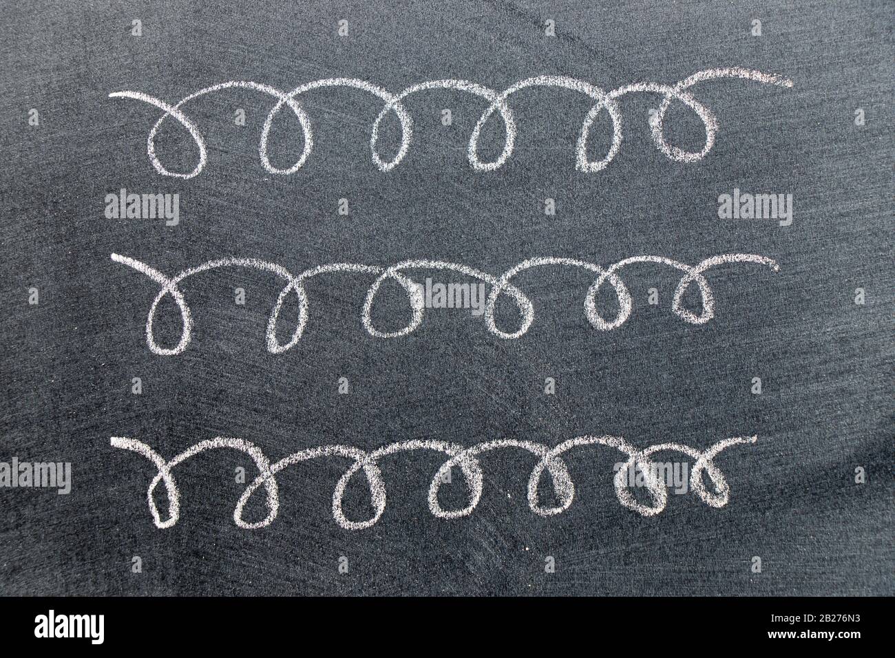 White color chalk hand drawing in set of curve or wavy line shape on ...