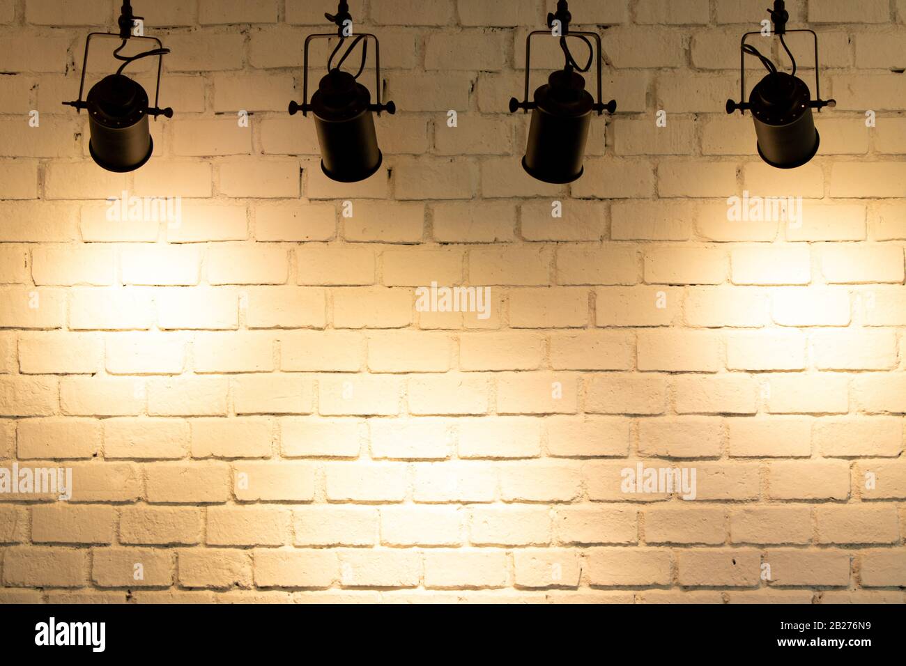 Hanging spotlight illuminate at brick wall background with copy space ...