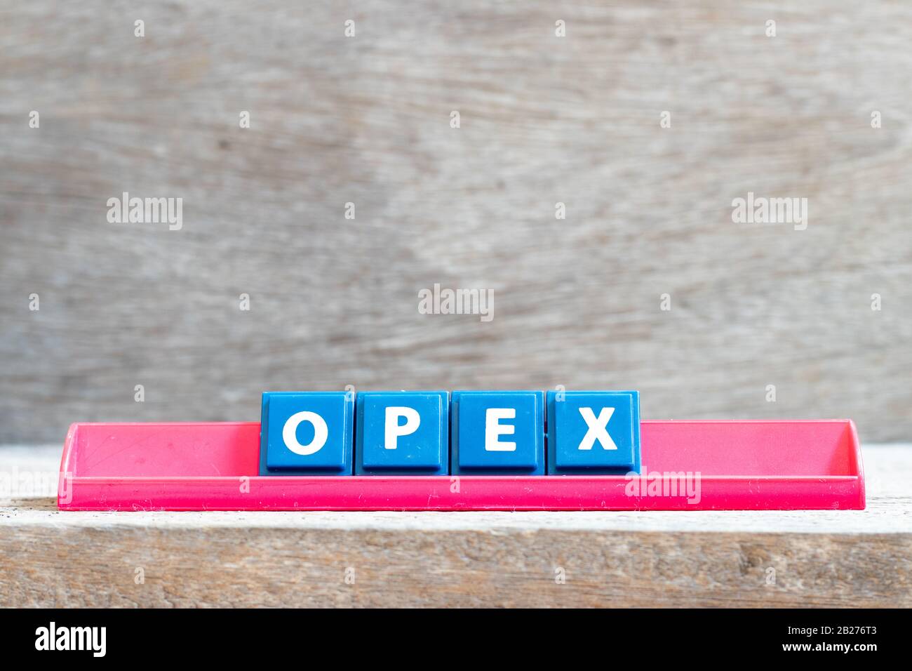 Tile letter on red rack in word opex (abbreviation of operating expense ...