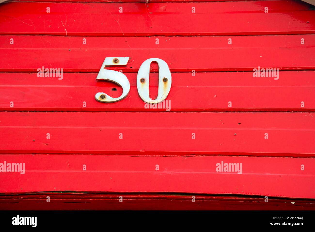 Chromium plated metal number 50 fixed to a red beach hut Stock Photo ...