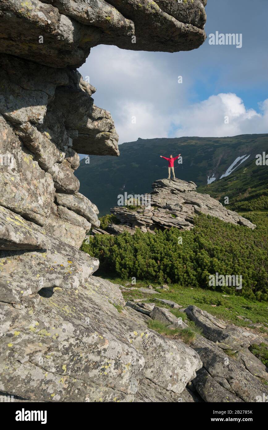 Small human figure in a red jacket among the majestic rocks Stock Photo ...