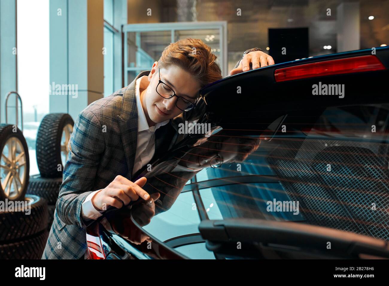 pleasant handsome man visisiting car dealership. Handsome man is ...