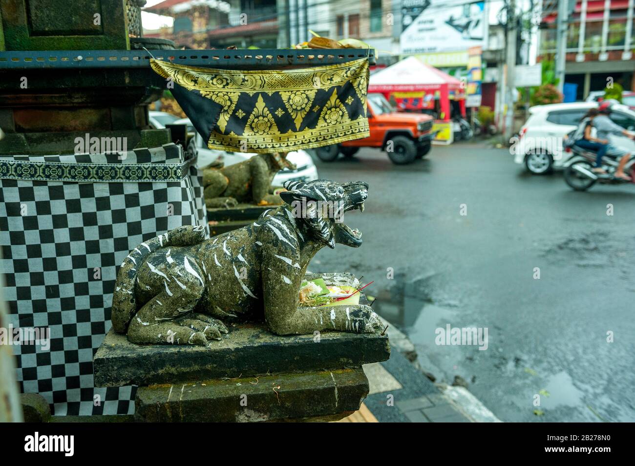 Carved Tiger statues, or Dvarapala, guarding a small Hindu shrine at a ...