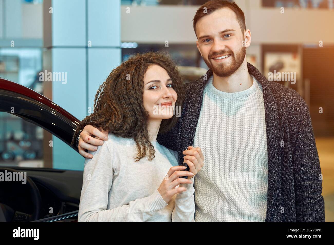 smiling loving couple is renting a car for travelling, couple has got ...