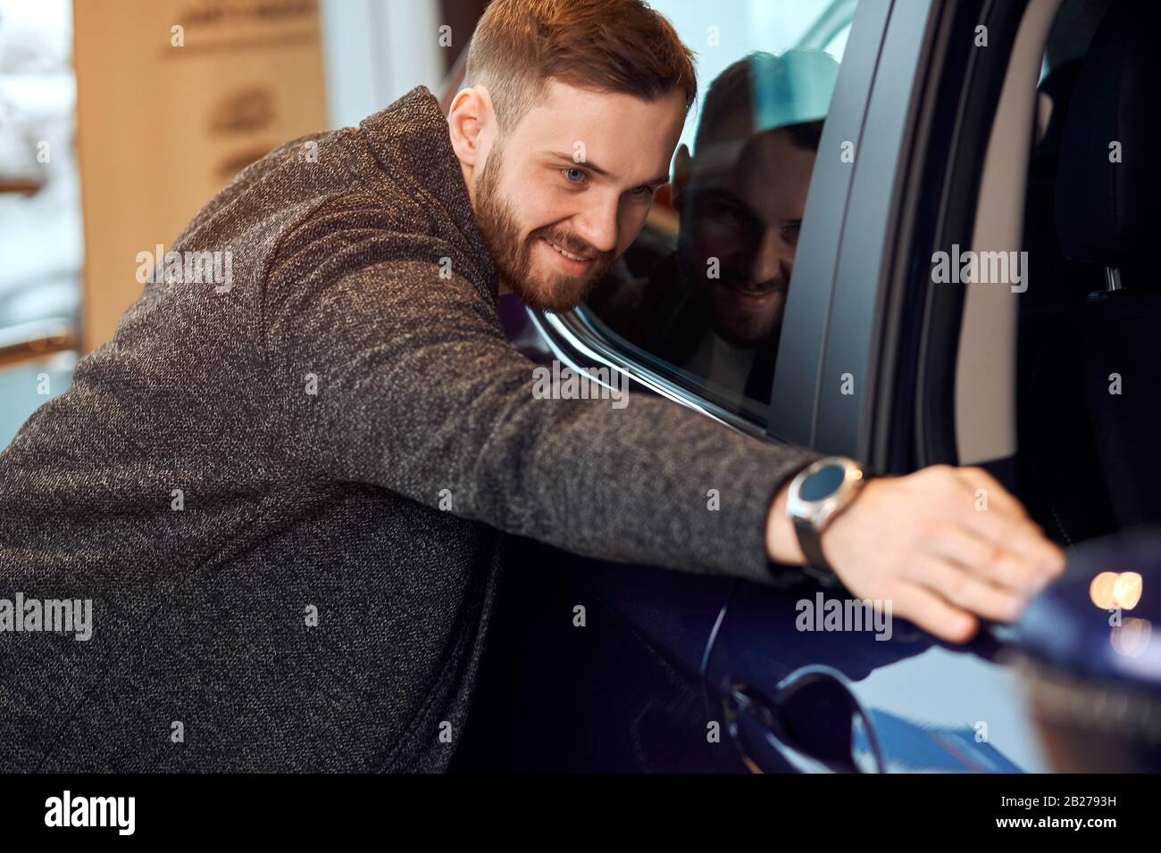 smiling positive guy hugging his car, cleaning, wiping car before ...