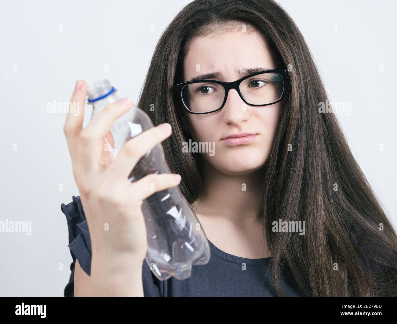 Long-haired Brunette Bespectacled Teen Girl Looking at Empty Plastic ...
