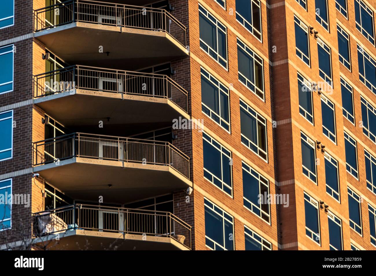 Side lit red brick high rise building with close up of the balconies ...