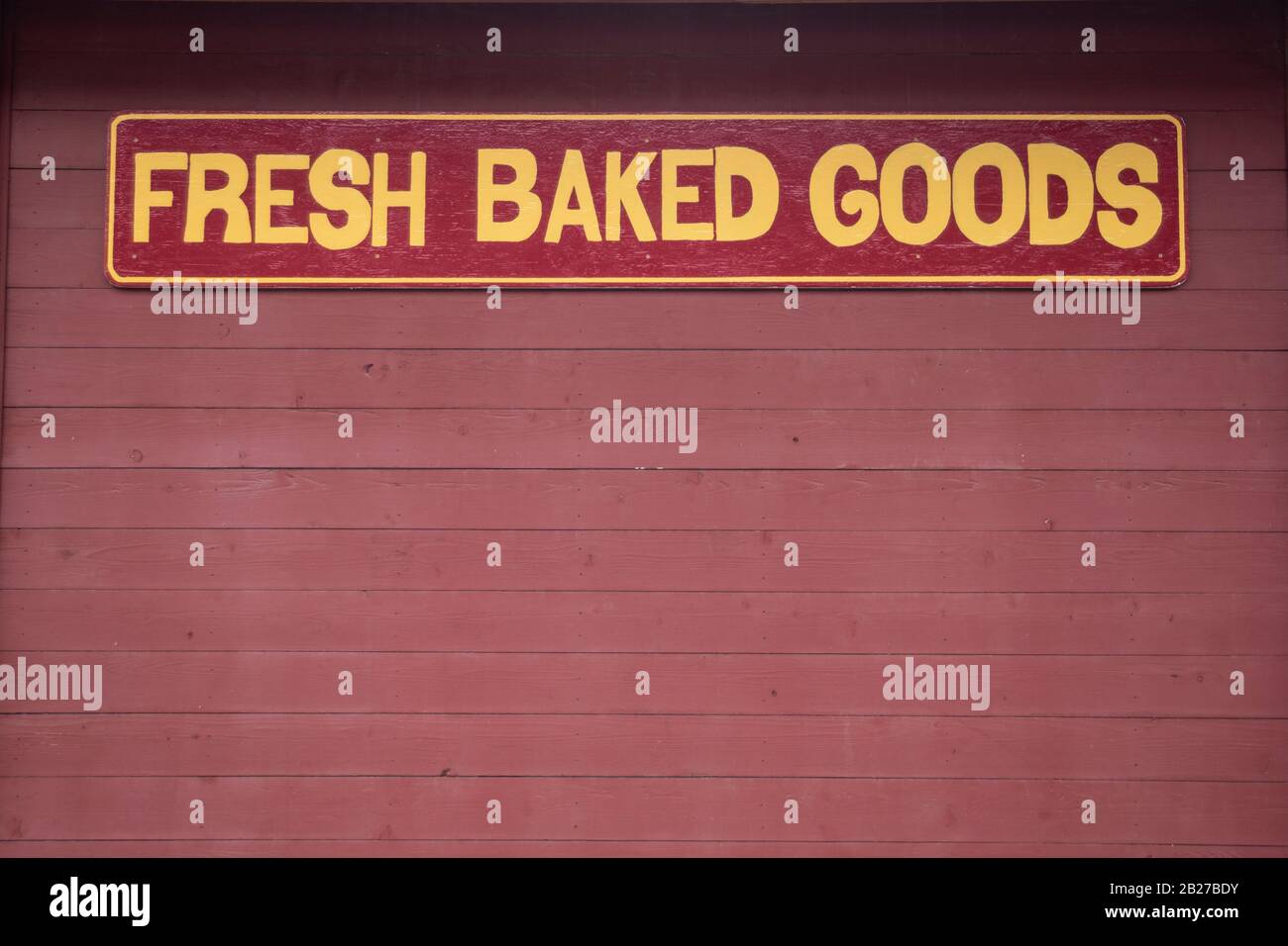 Fresh Baked Goods Sign hanging on a red exterior wall Stock Photo - Alamy