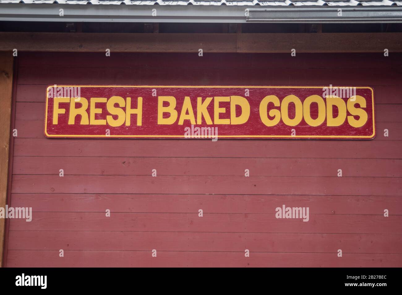 Fresh Baked Goods Sign hanging on a red exterior wall Stock Photo - Alamy