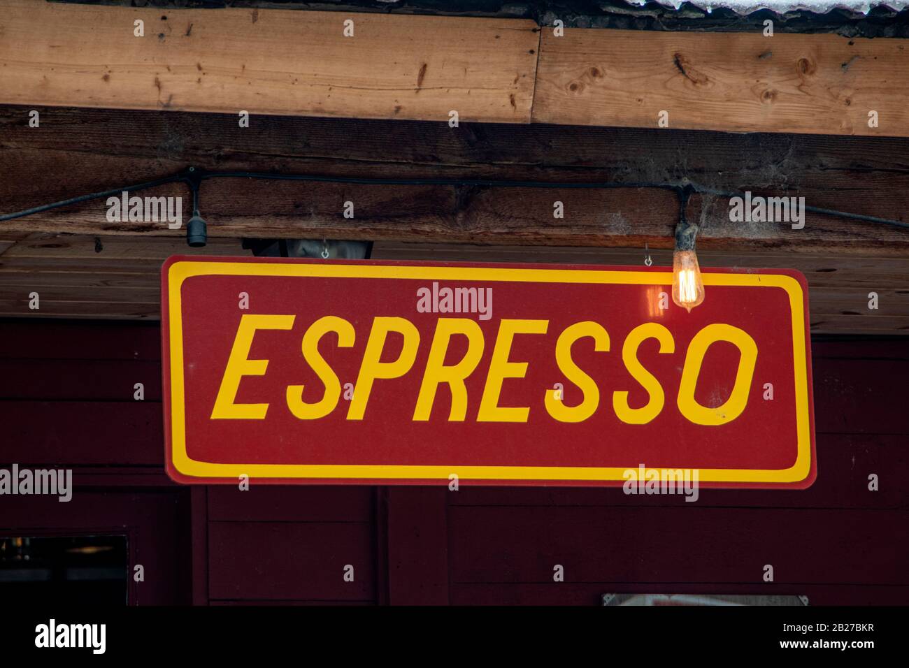 Red and Yellow Expresso sign advertisement hanging from a wooden rafter ...