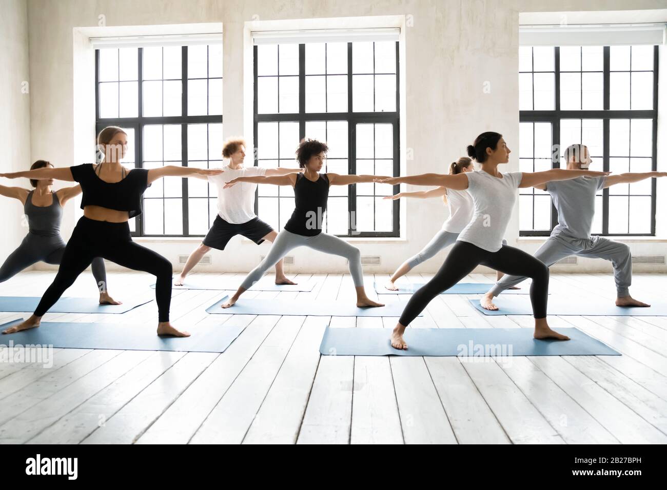 Group of people practicing yoga asanas doing Warrior Two exercise Stock ...