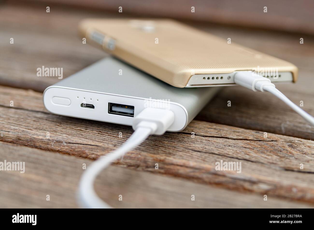 Smartphone charging with powerbank on the bench Stock Photo - Alamy