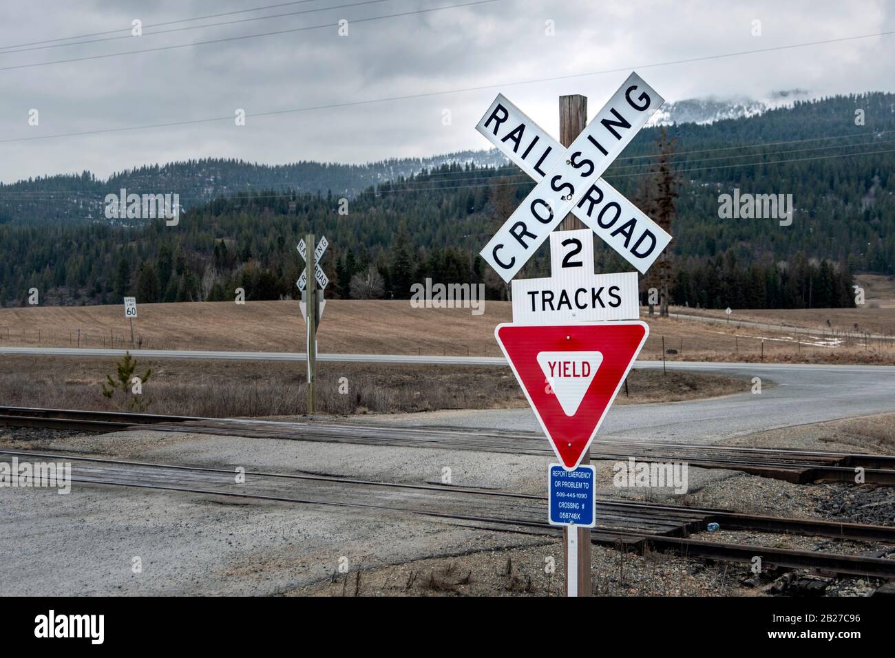 Railroad Crossing sign at a rural junction under the cloudy sky Stock ...