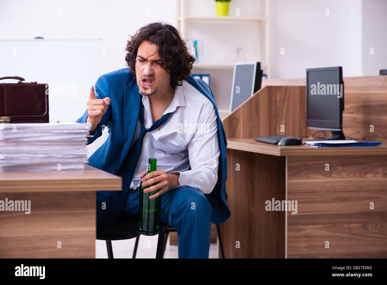 The young drunk employee in the office Stock Photo - Alamy