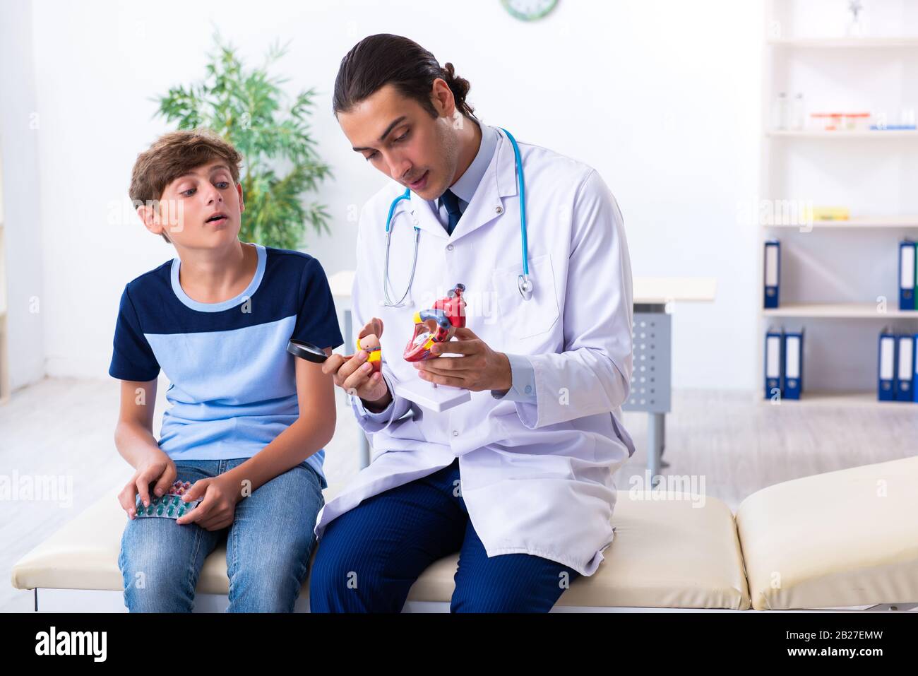 The young male doctor examining boy in the clinic Stock Photo - Alamy