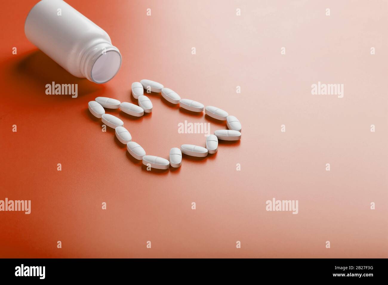 Calcium vitamin in the form of a tooth spilled out of a white jar on a ...